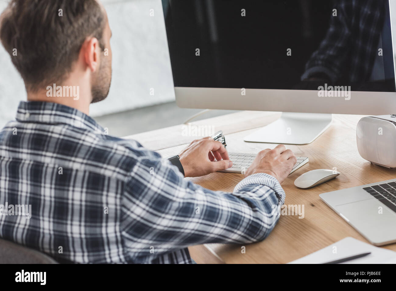 back view of young programmer using desktop computer at workplace Stock ...