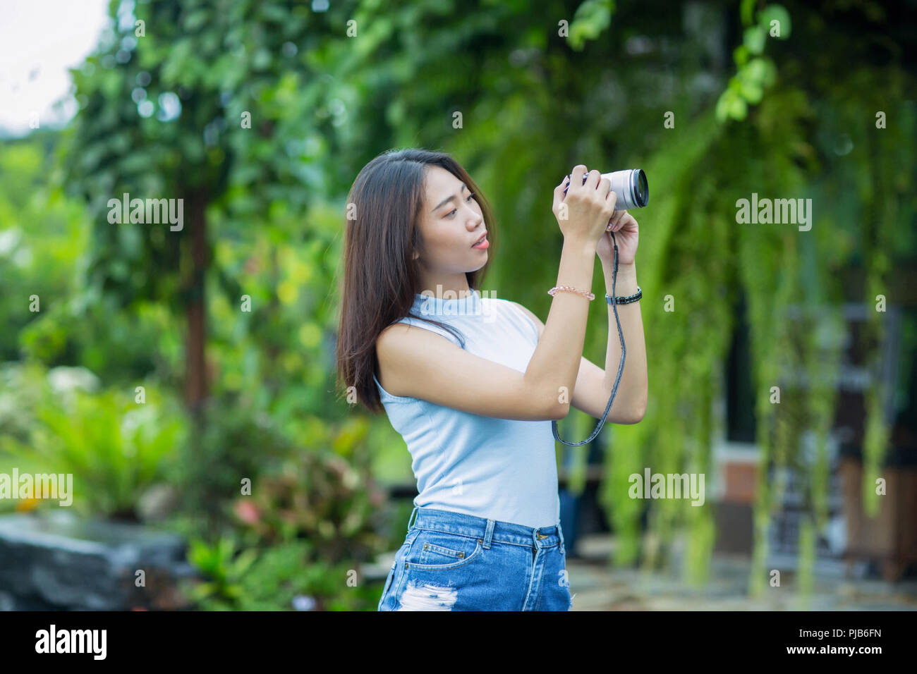 Young asian girl taking photo with camera in the garden Stock Photo - Alamy