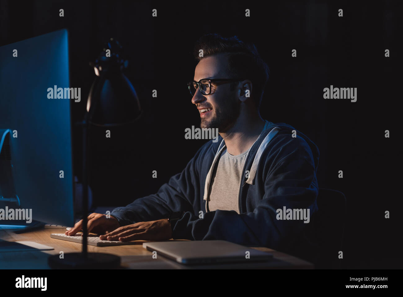 smiling young programmer in eyeglasses working with desktop computer at night Stock Photo - Alamy