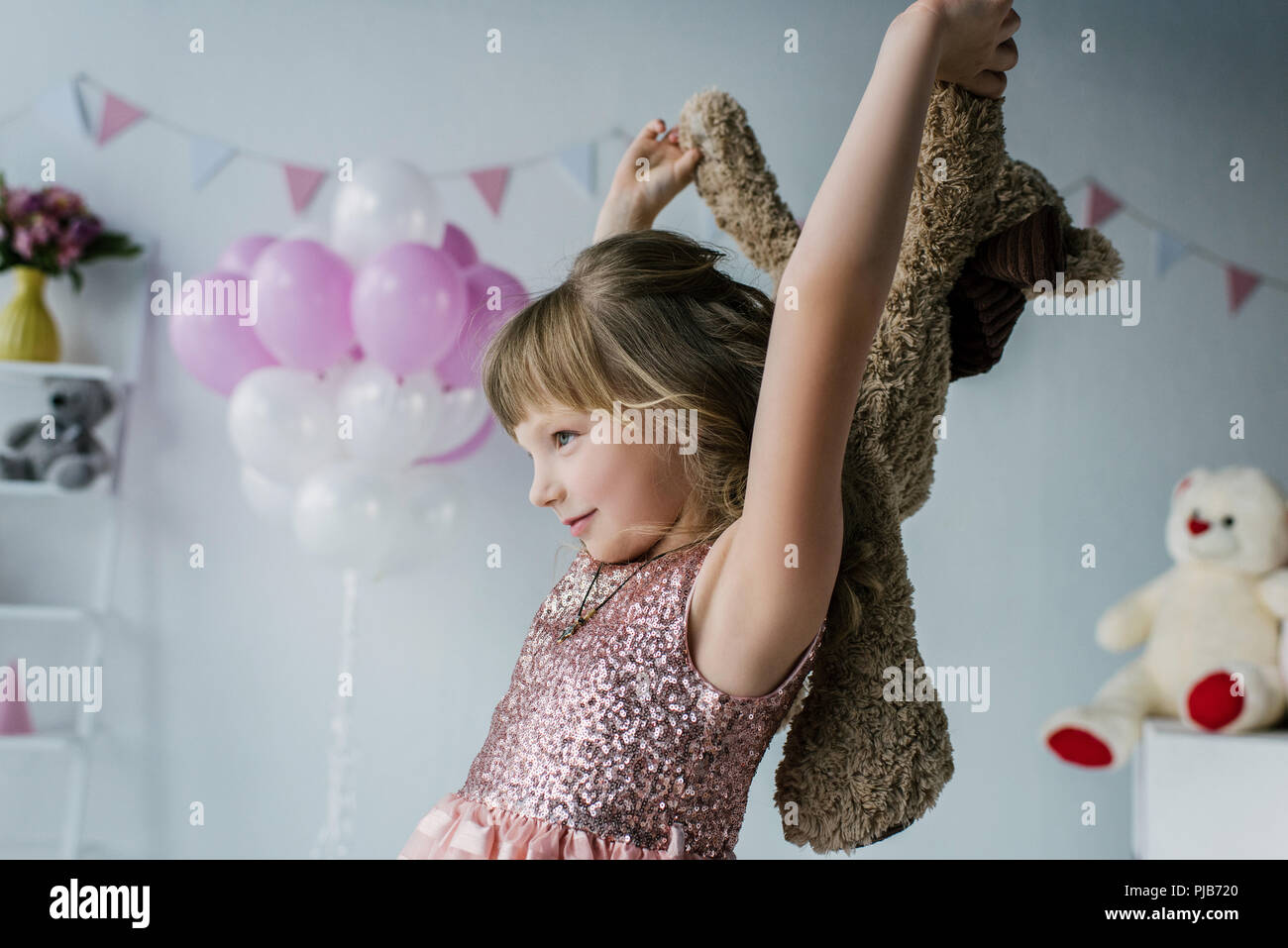 side view of smiling little kid holding teddy bear Stock Photo - Alamy