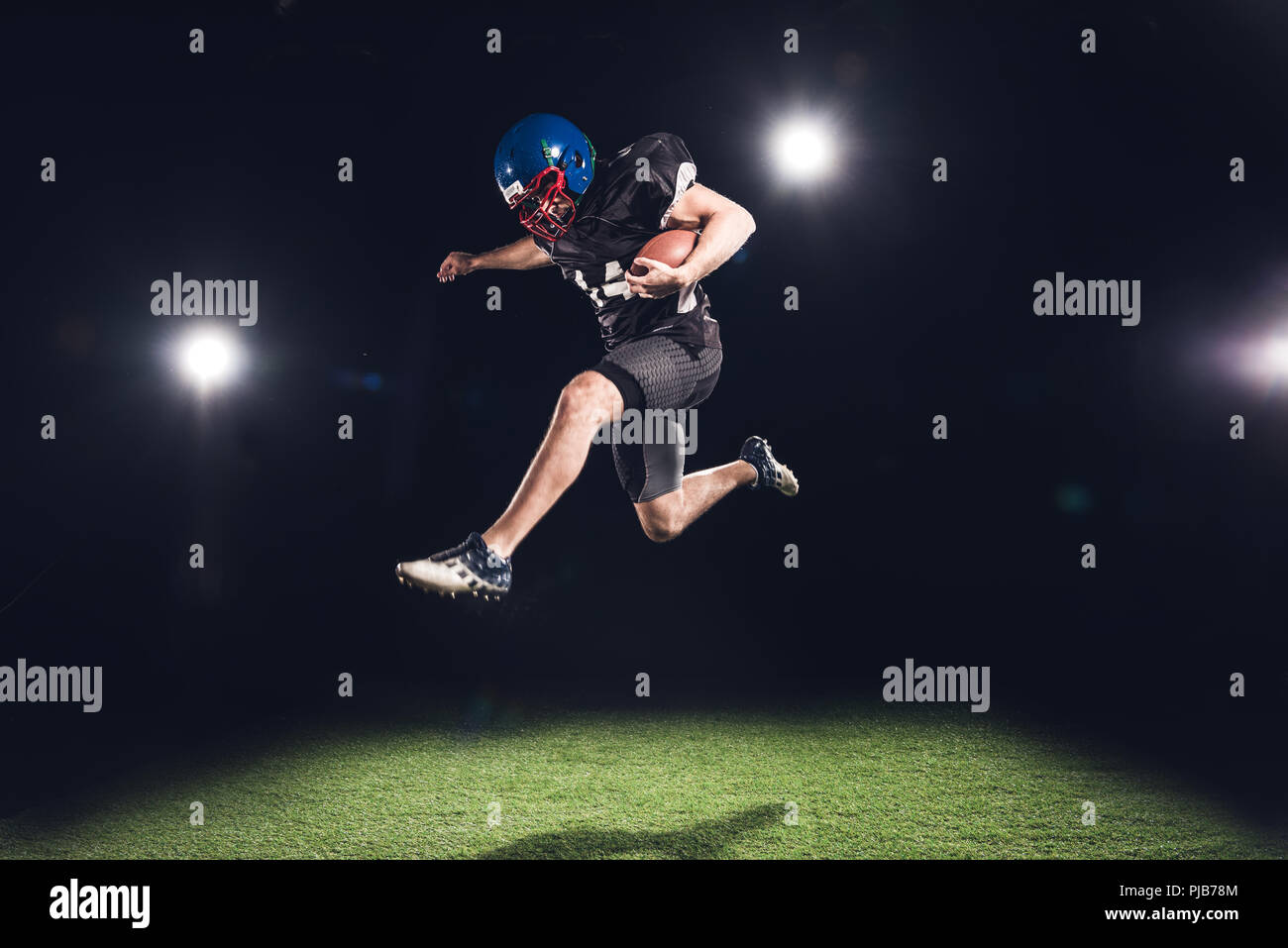 american football player jumping with ball over green grass under ...