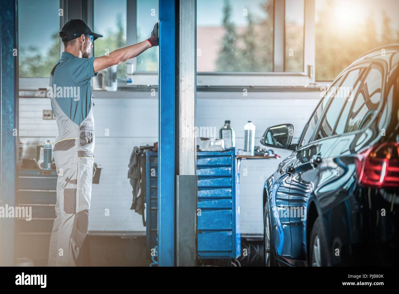 Auto Service Worker in Front of Heavy Duty Car Lift. Preparing For the ...