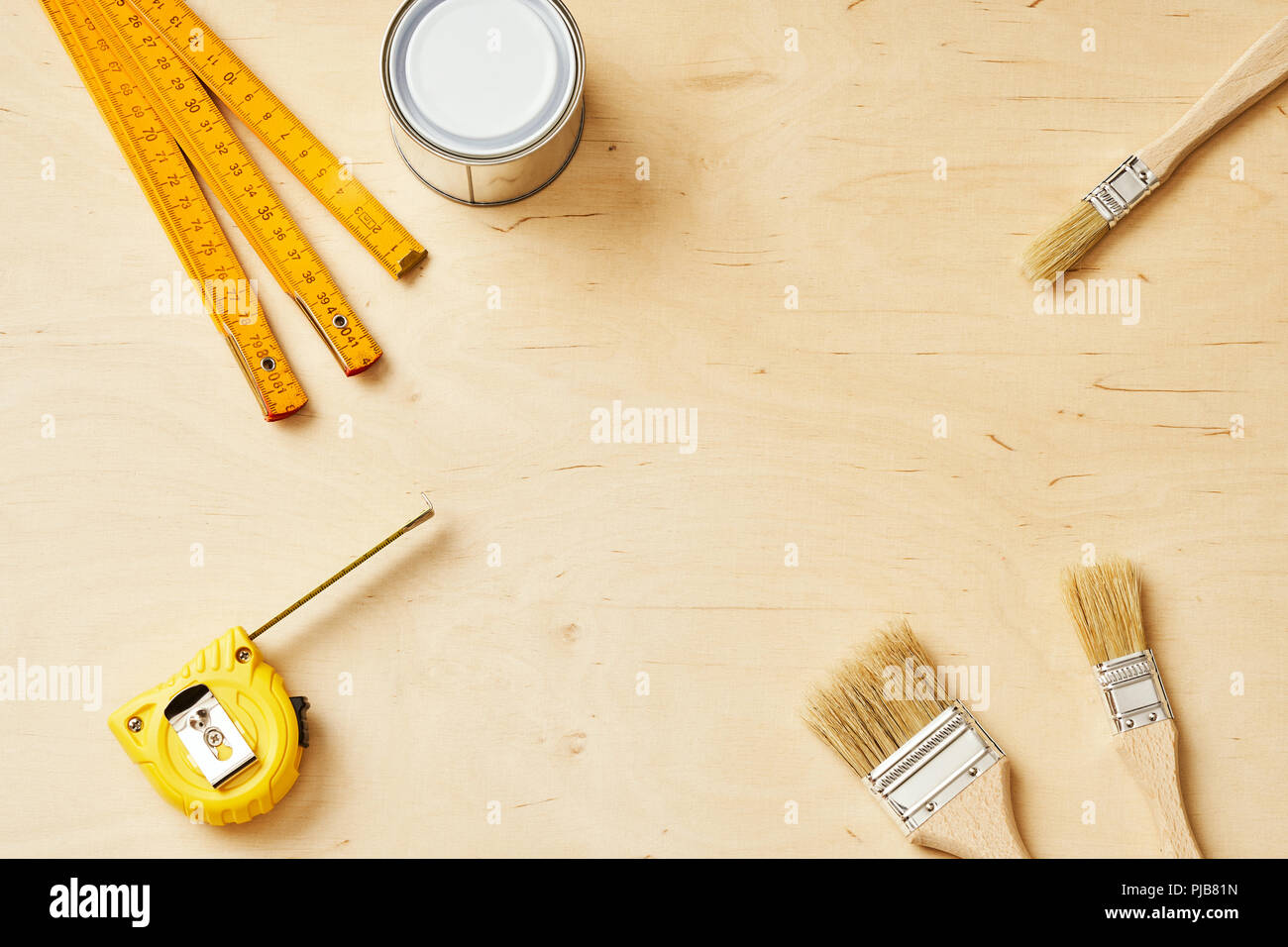 background with a ruler, tape measure, brushes and paint cans on a ...