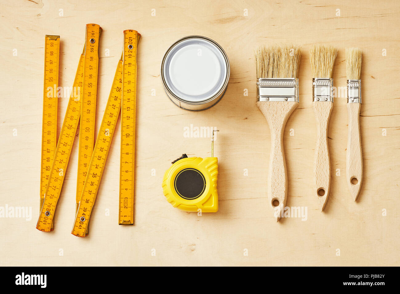 background with a ruler, tape measure, brushes and paint cans on a ...