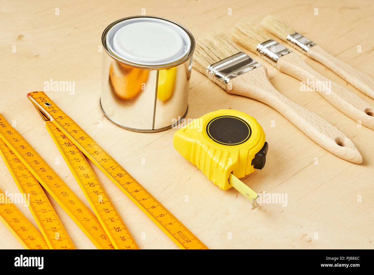 background with a ruler, tape measure, brushes and paint cans on a ...