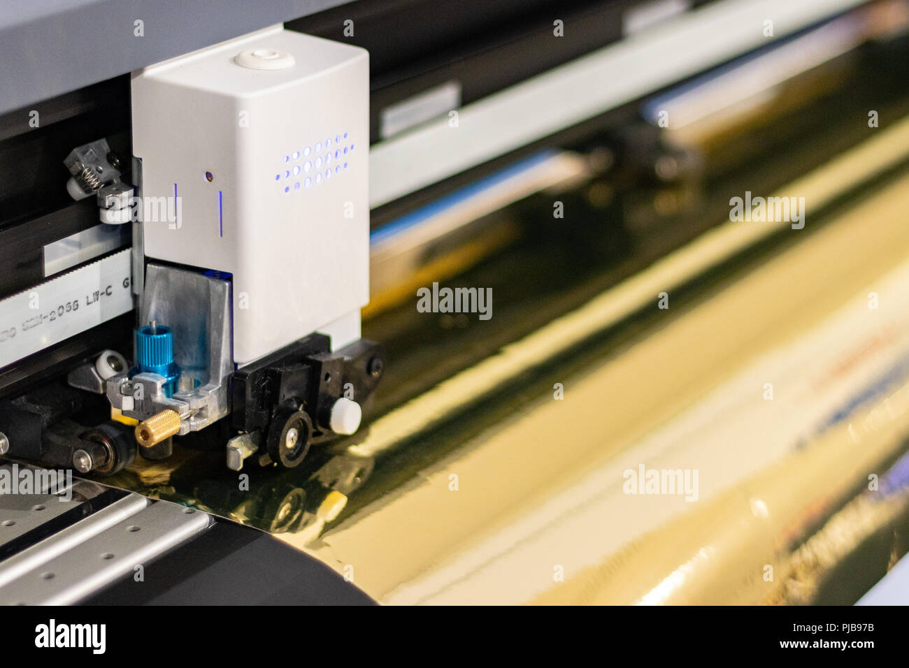 Big professional printer, processing a large scale glossy vinyl roll ...