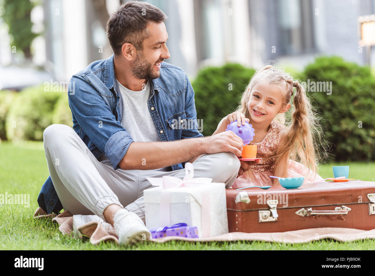 father and daughter playing tea party at lawn Stock Photo - Alamy