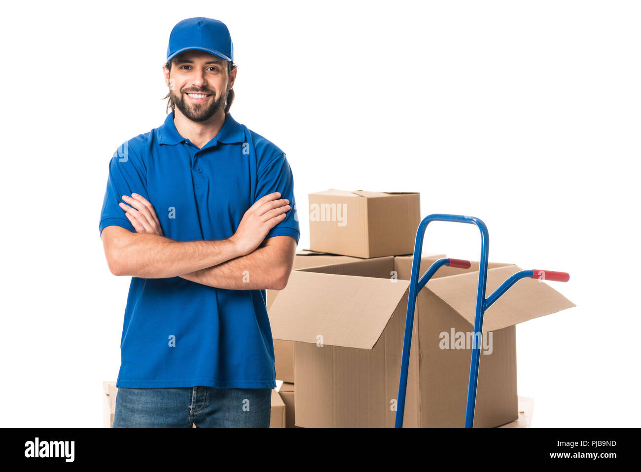handsome delivery man standing with crossed arms and smiling at camera ...