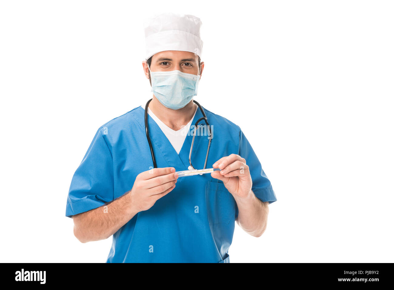 surgeon in medical mask holding thermometer and looking at camera ...