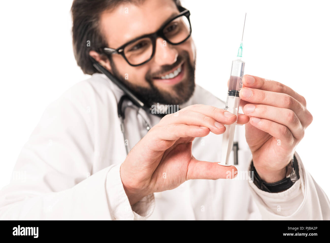 smiling doctor holding syringe and talking by smartphone isolated on ...