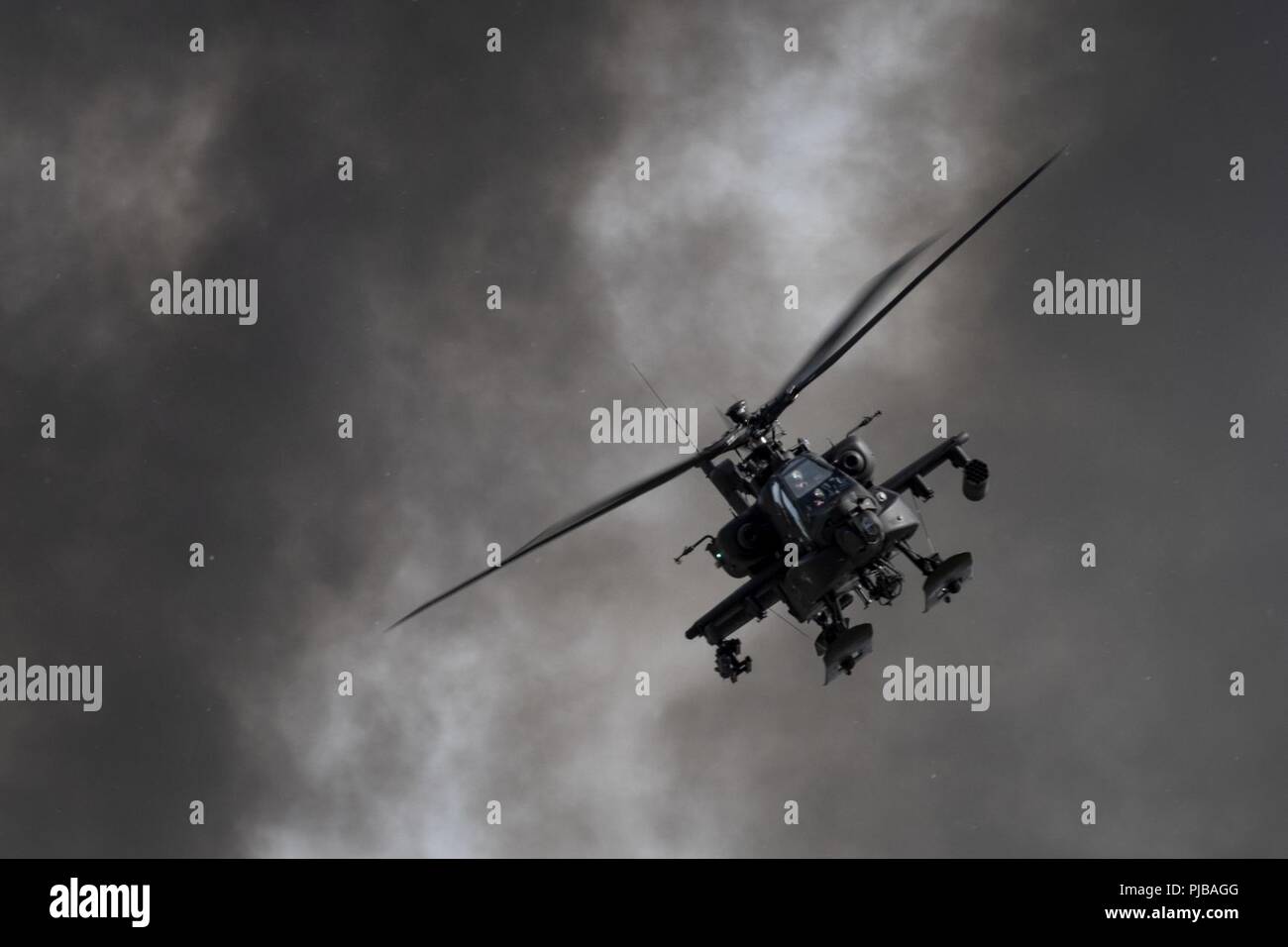 A U.S. Army AH-64 Apache attack helicopter flies through smoke from an ...