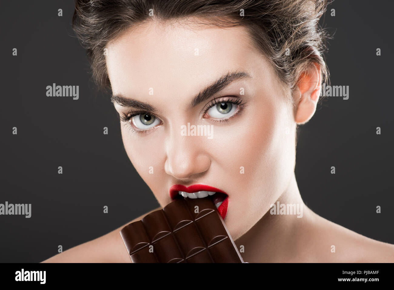 Woman biting chocolate hi-res stock photography and images - Alamy