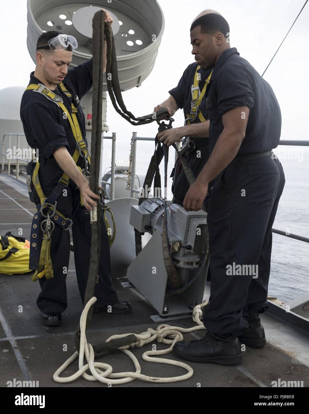 ATLANTIC OCEAN (July 2, 2018) Sailors connect an electrical hoist to ...