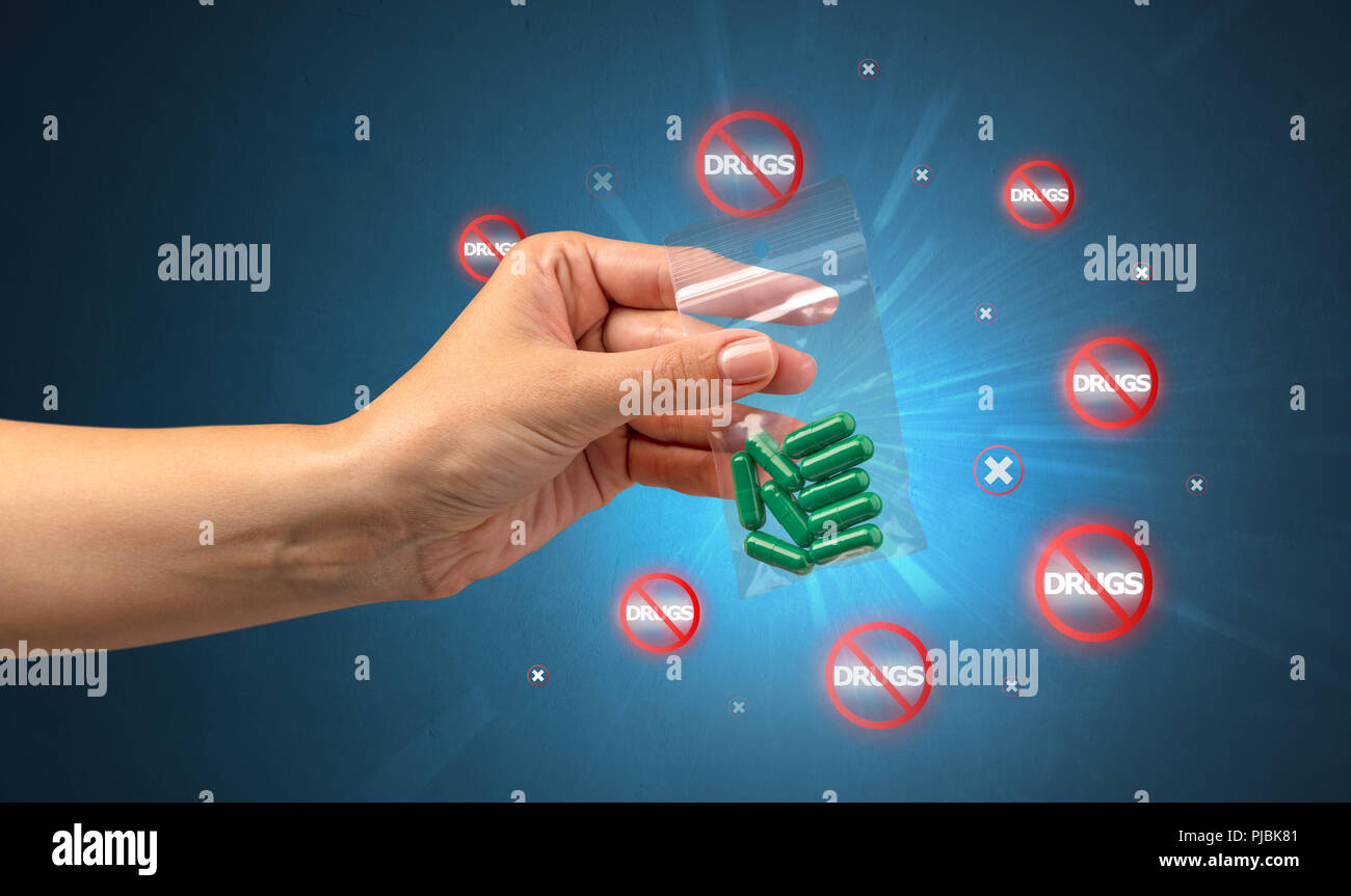 Hand giving pills with anti-drug concept and not allowed signs around ...