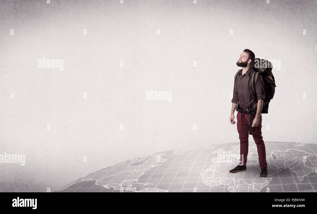 Handsome young man with a backpack on his back standing on a world map ...