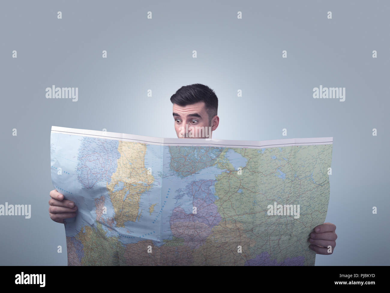 Handsome young man holding map Stock Photo - Alamy