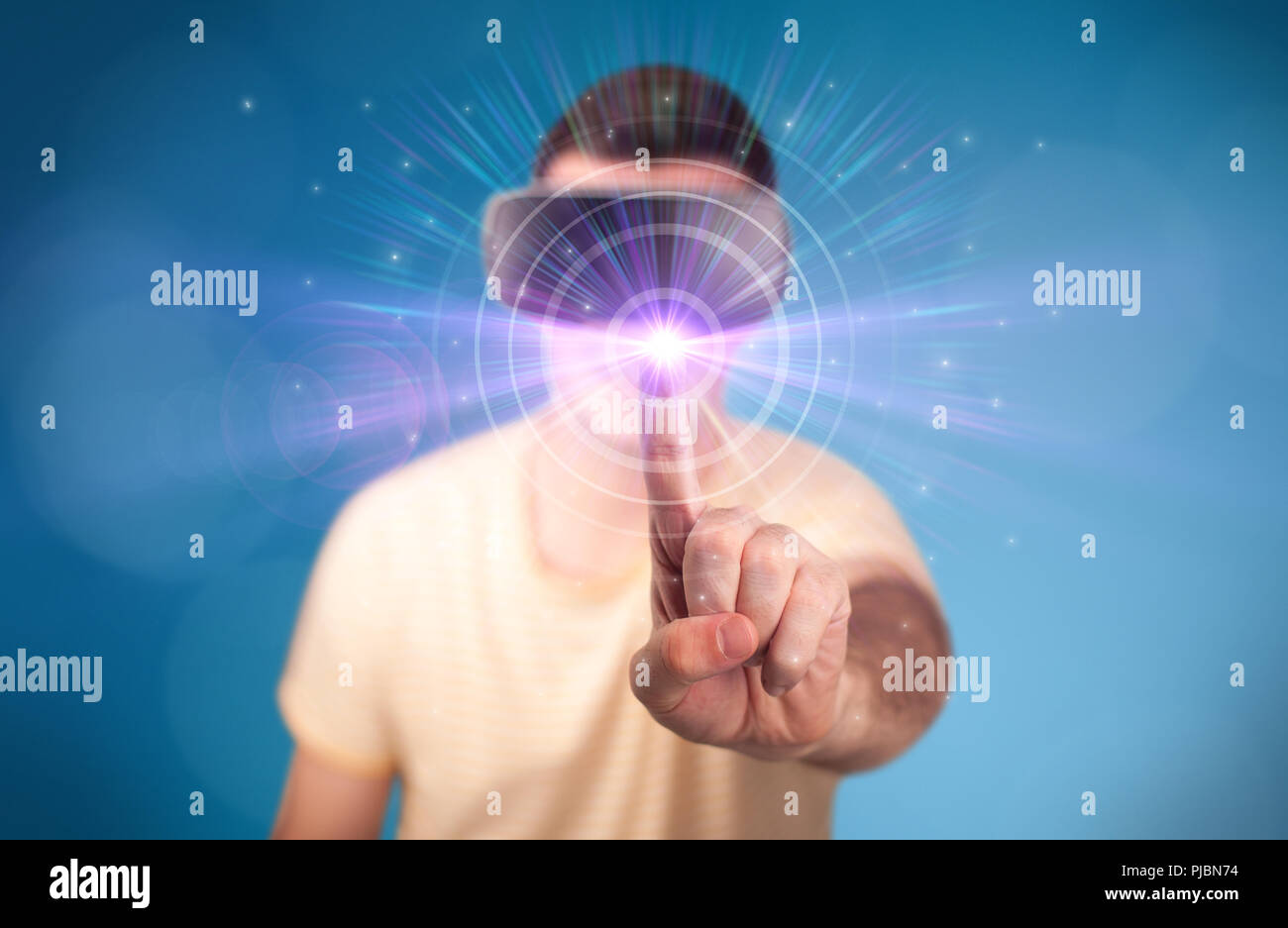Young impressed man wearing virtual reality goggles with blue circles ...
