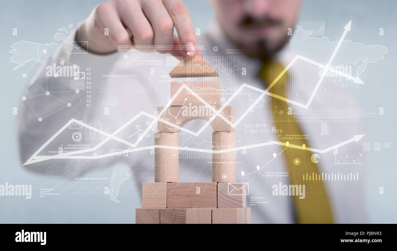 Young handsome businessman using wooden building blocks with data and ...