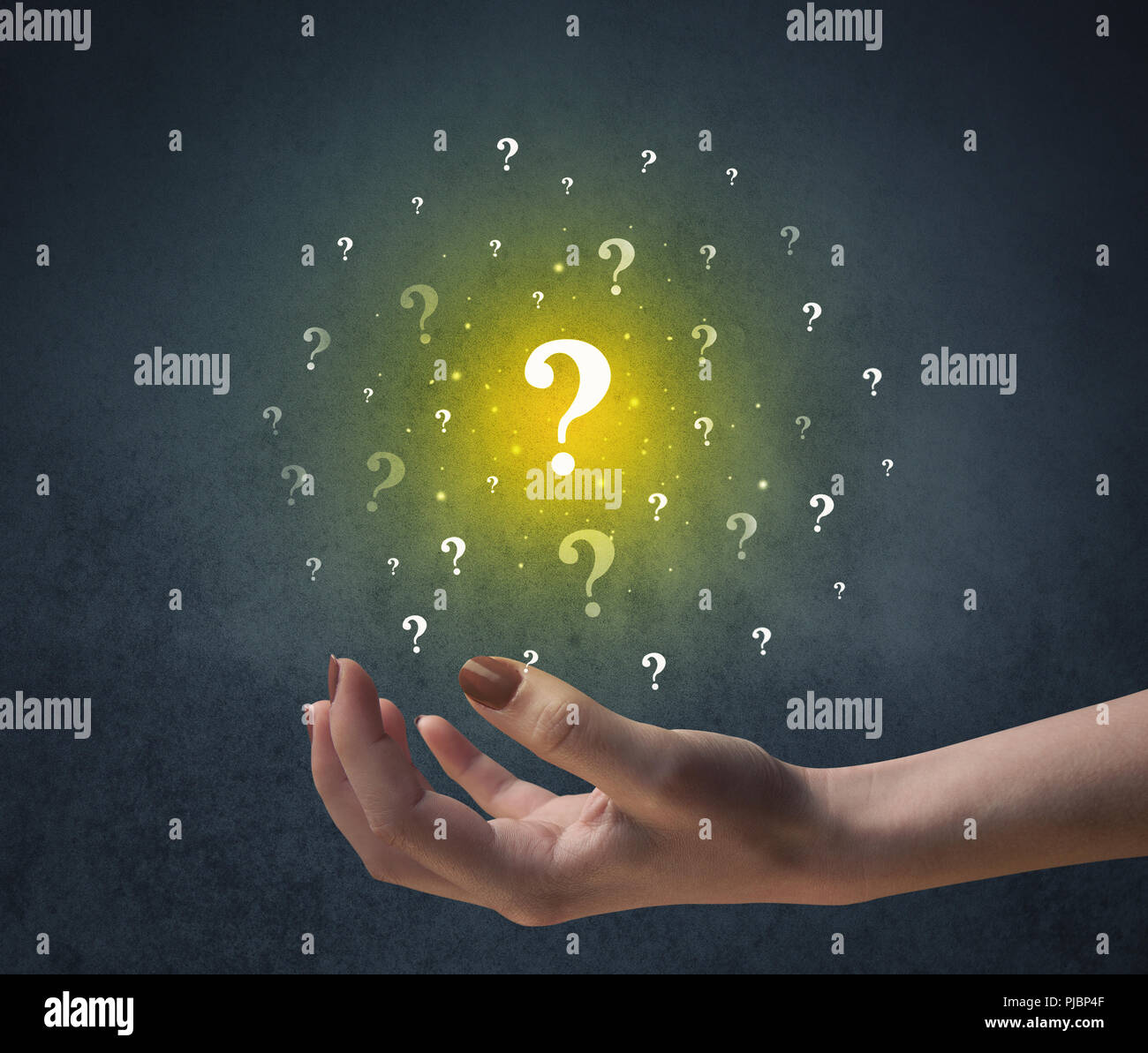 Yellow question marks hovering over young hand Stock Photo - Alamy