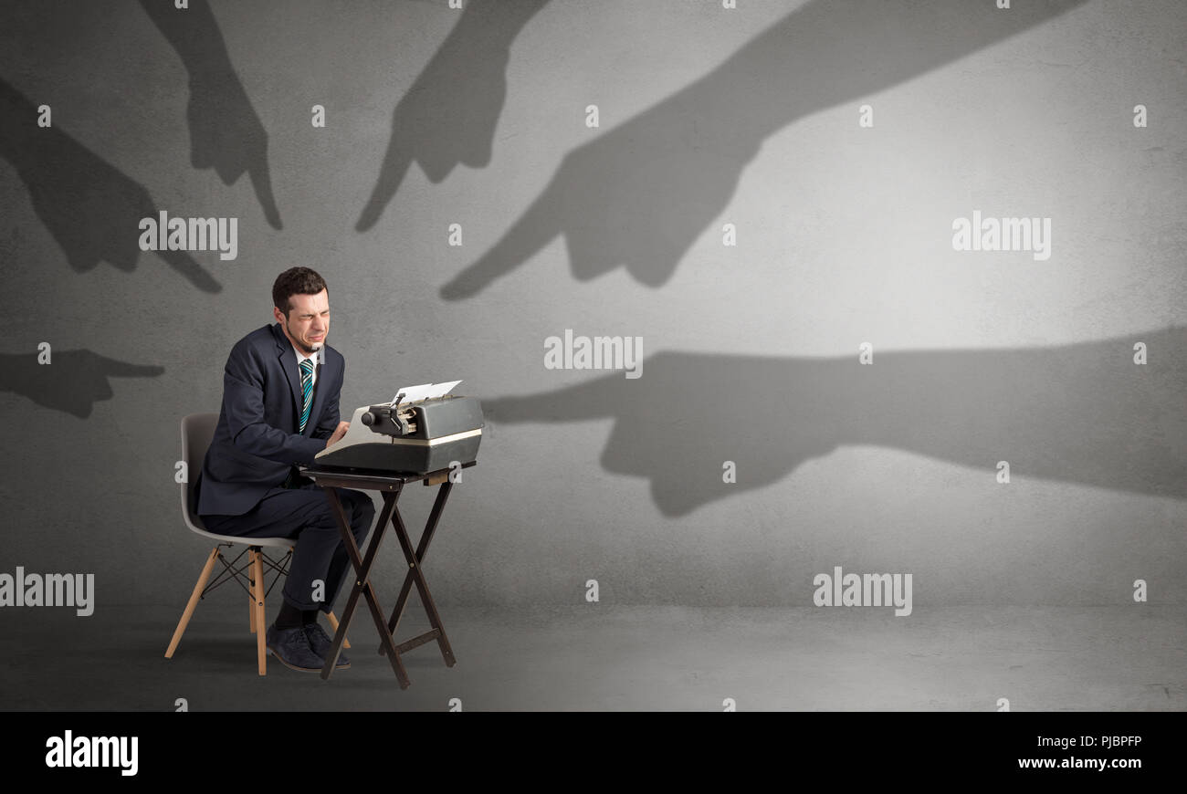 Shadow hand pointing at a small afraid worker Stock Photo - Alamy