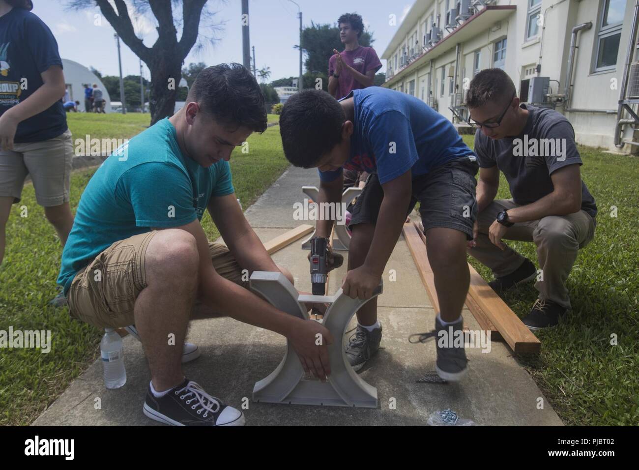 U.S. Marine Cpl. Michael Malley helps a member of the Boy Scouts Troop ...