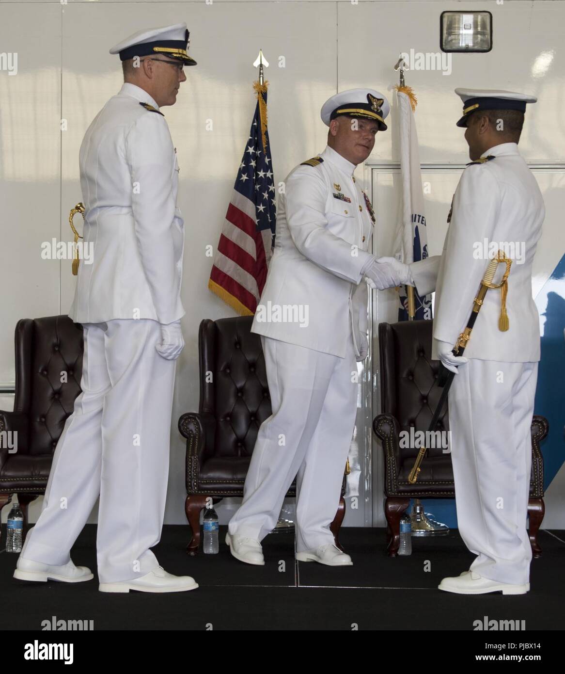U.S. Coast Guard Capt. Mark Shepard, the presiding official, shakes ...