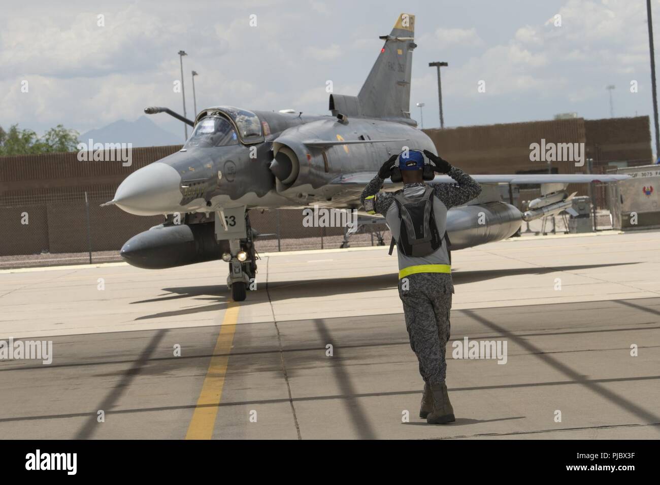 A Colombian Air Force crew chief guides a Colombian Kfir fighter jet ...