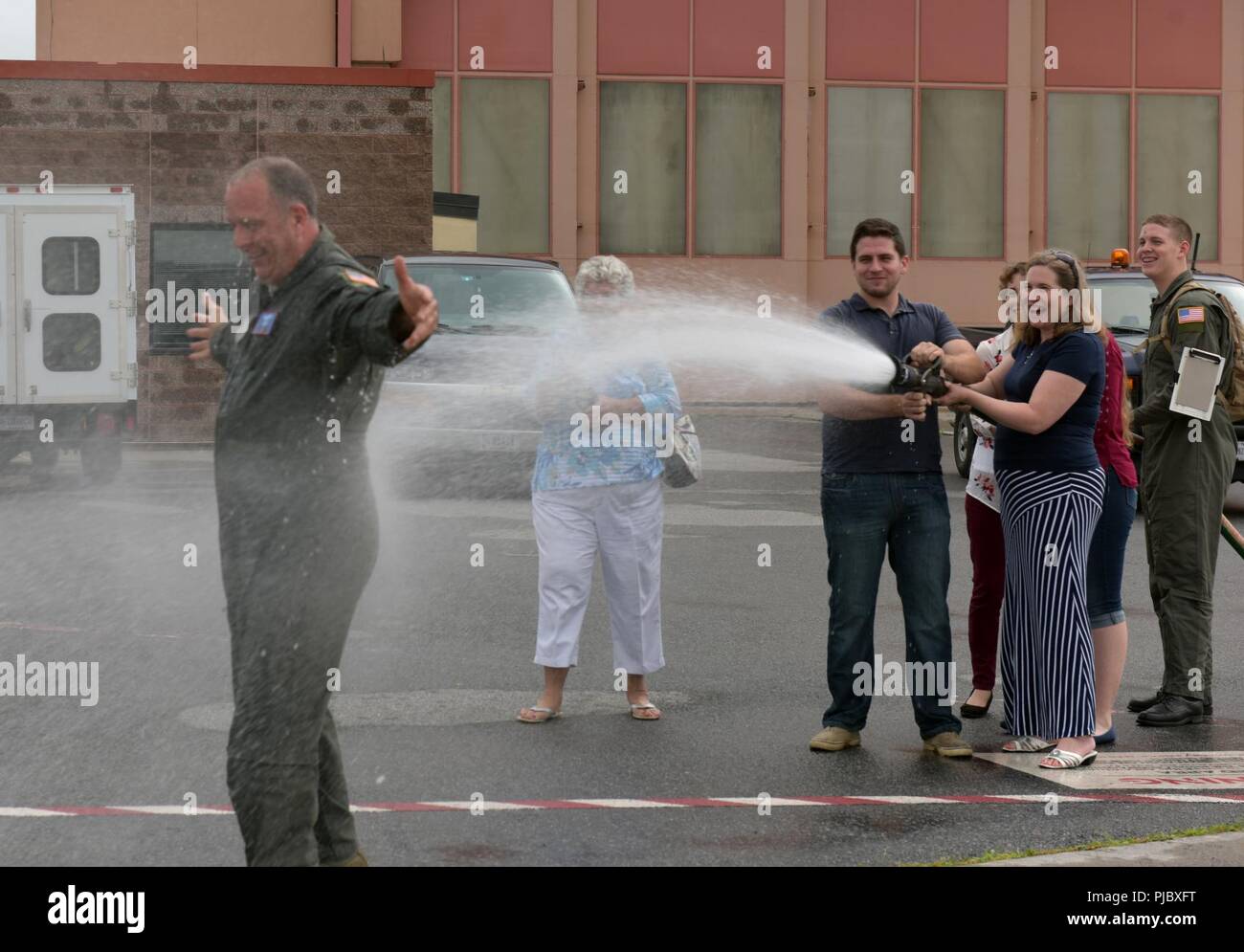 Family members spray with the hose for their fath's last flight of his ...