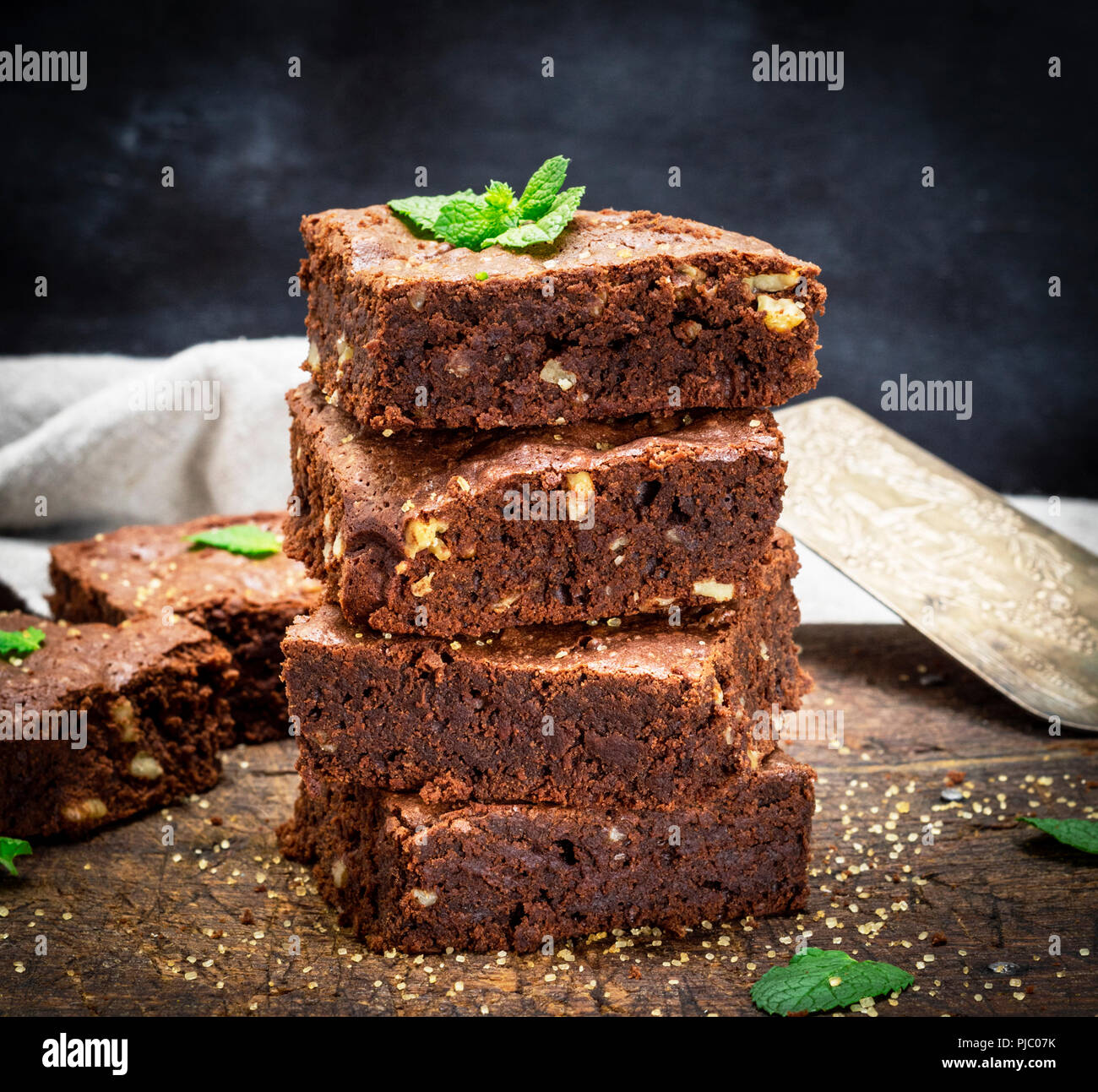 stack of baked square pieces of chocolate brownie pie with walnuts on ...