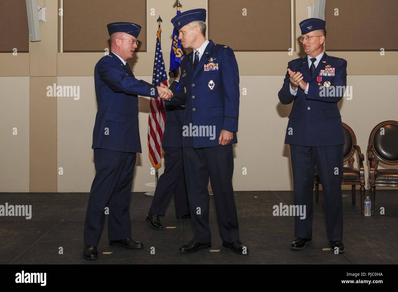 Col. Troy Endicott, 460th Space Wing commander, left, shakes the hand ...