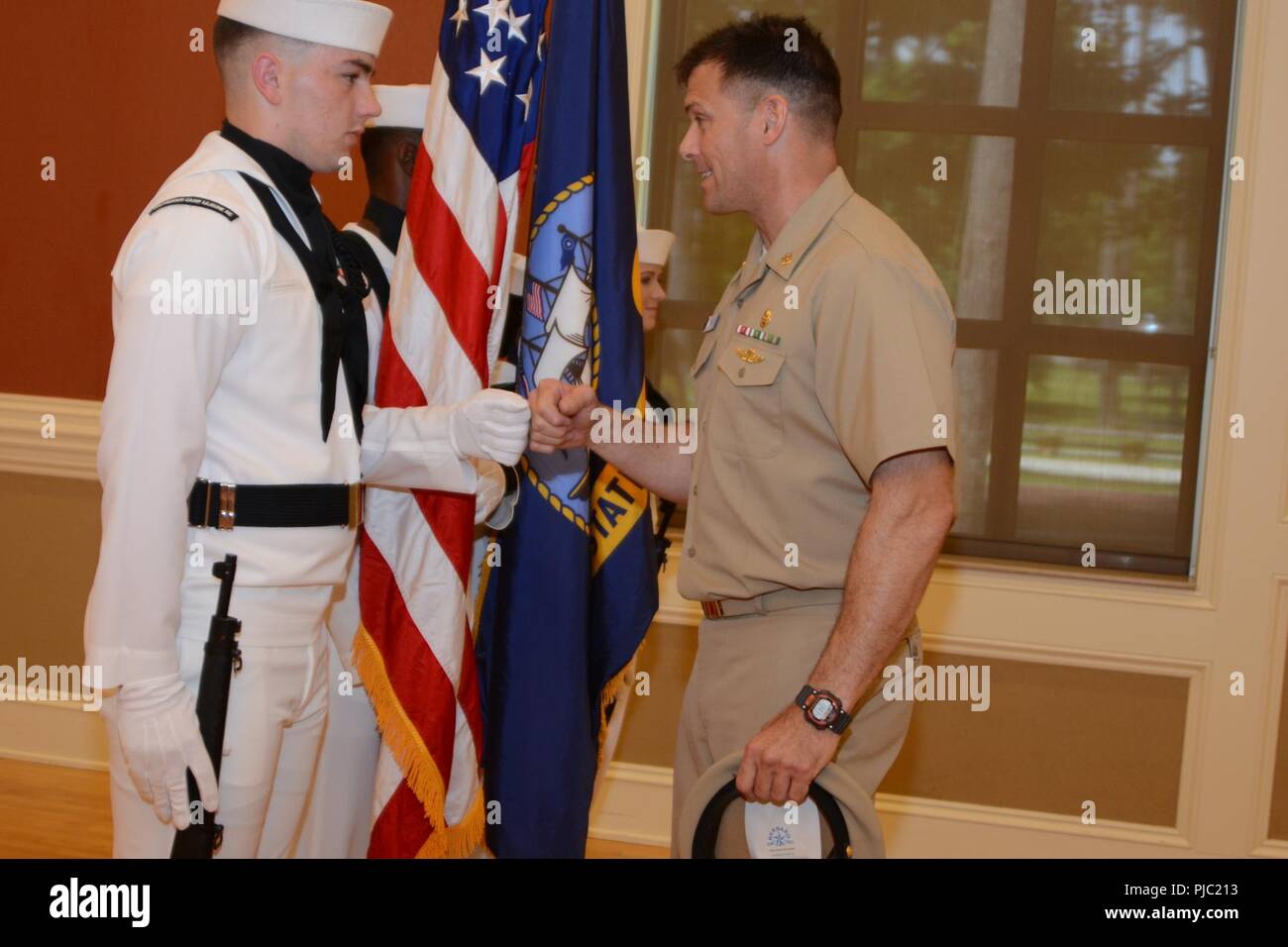 Master Chief James Baker fist bumps a member of the Color Guard before ...