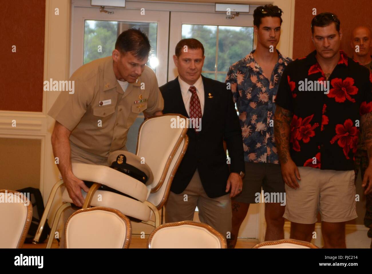 Master Chief James Baker helps set out additional seating prior to his ...