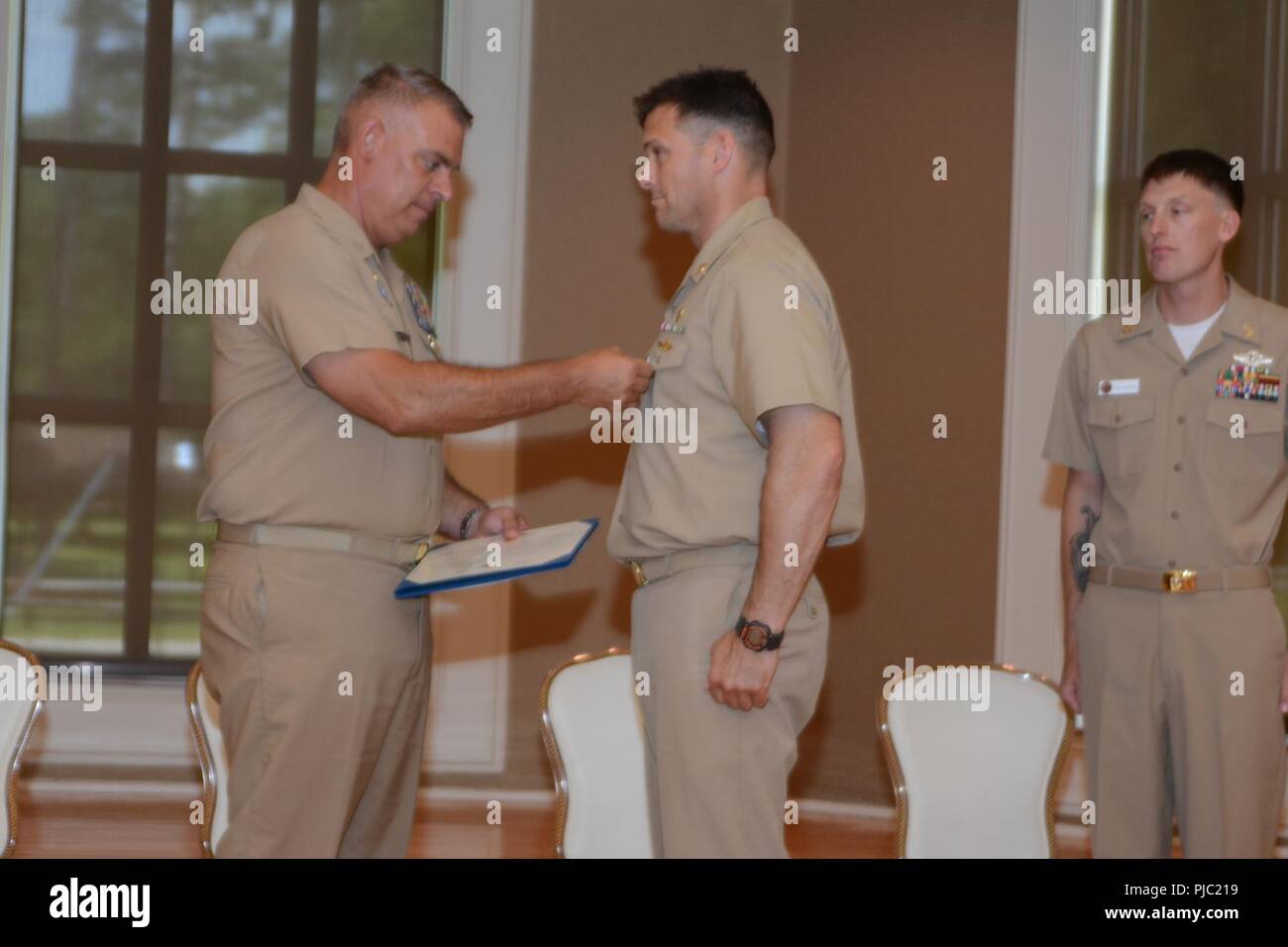 Master Chief James Baker receives the Meritorious Service Medal from ...
