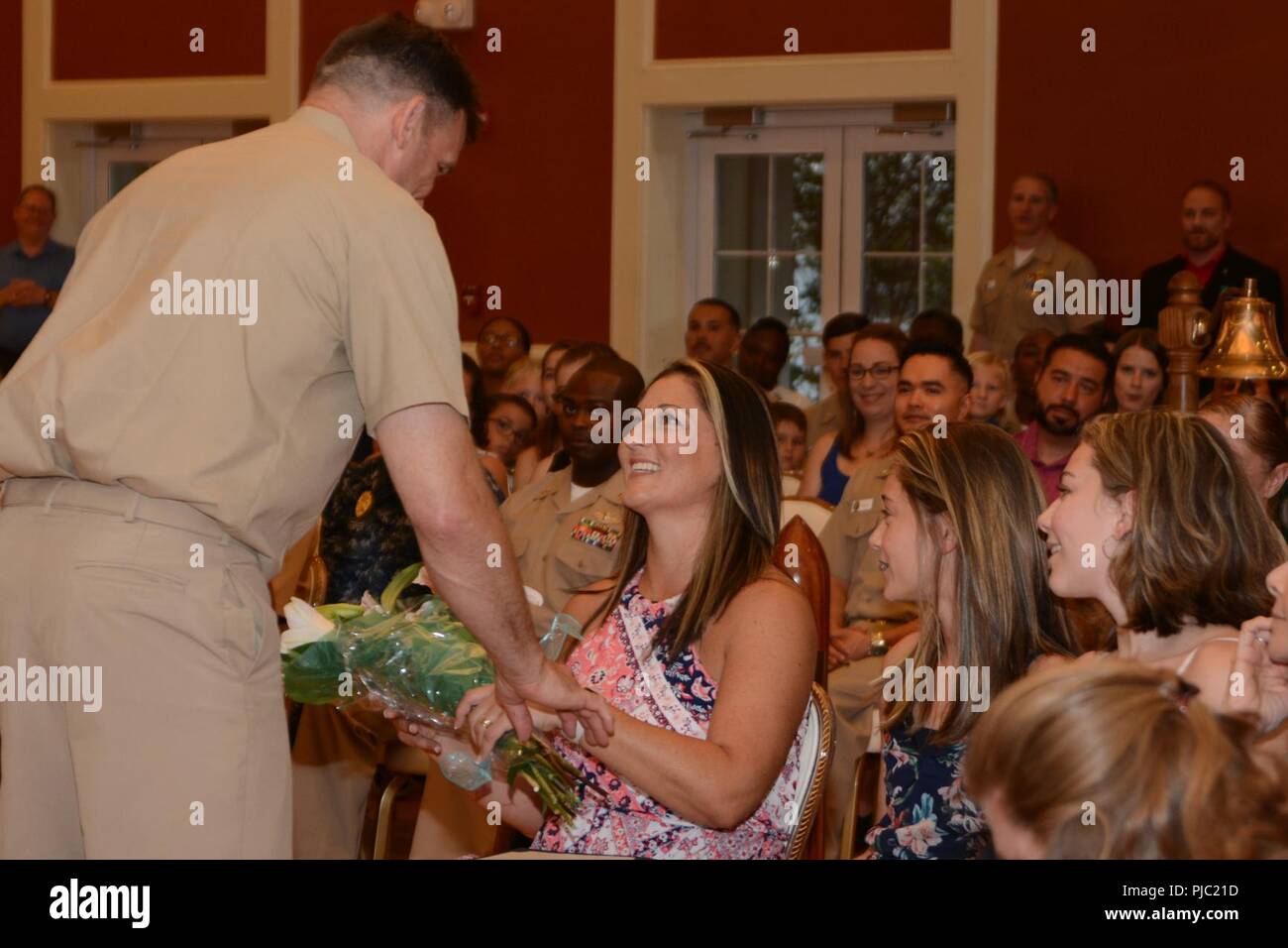 Master Chief James Baker presents flowers to his wife during his ...