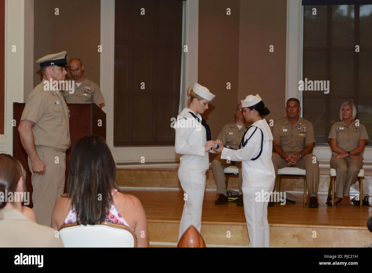 A flag is folded as Master Chief James Baker stands at attention during ...