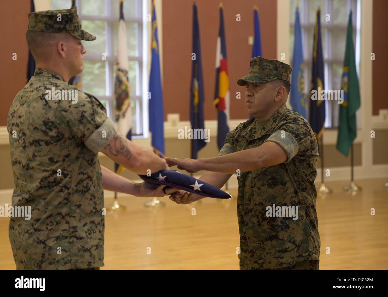 Capt. Jamie J. Grifaldo receives the American flag during his ...