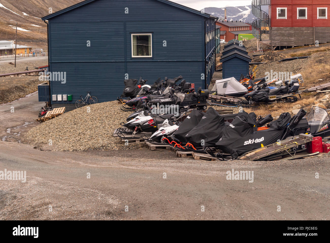 Snowmobiles parked on wooden pallets in the summer in Longyearbyen ...