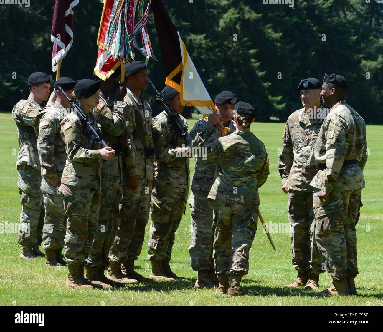 Incoming Commander Colonel Laura Elliot passes the unit colors to ...