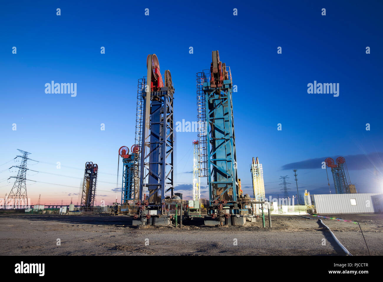 Oil field, the tower type pumping unit in the evening Stock Photo - Alamy