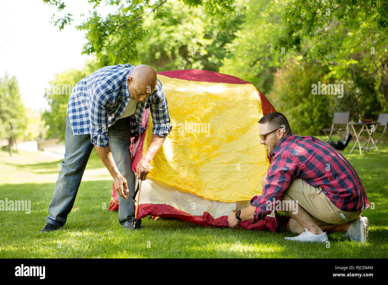 Friends hanging out camping and setting up a tent Stock Photo - Alamy