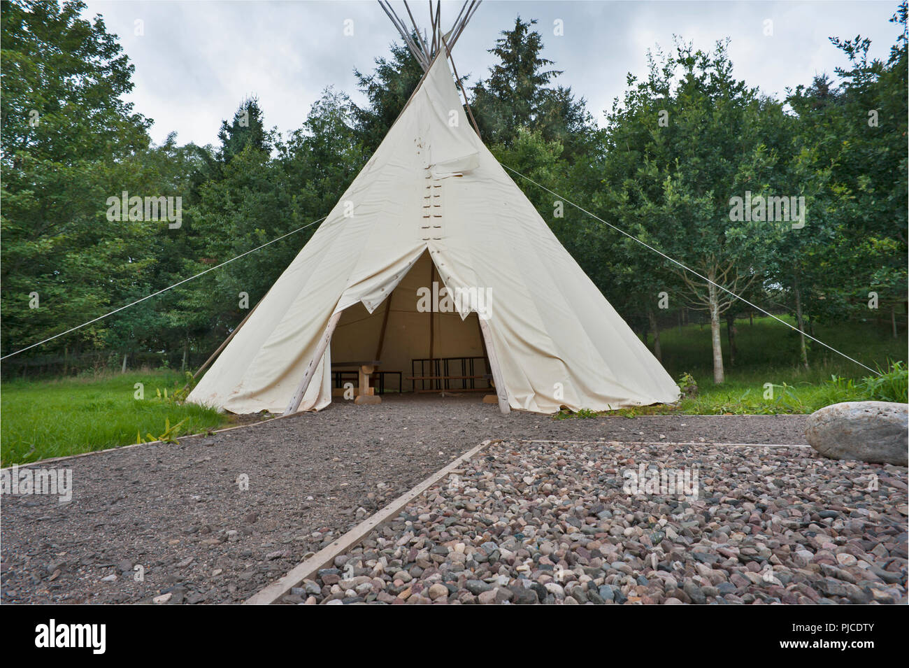 Extrrnal view of a canvas and tipi or teepee with entrance flap open ...