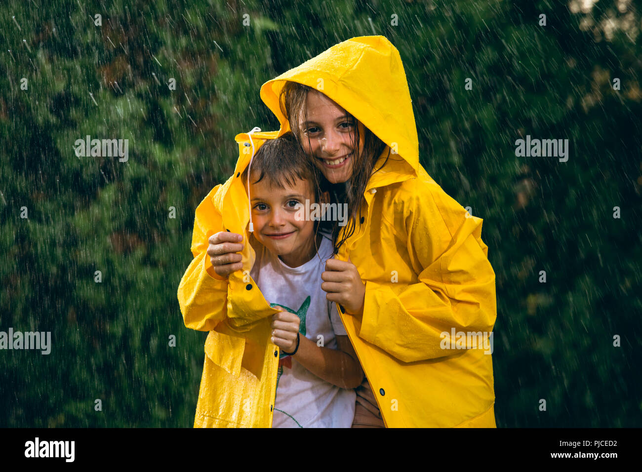 hiding under raincoat from rain Stock Photo - Alamy