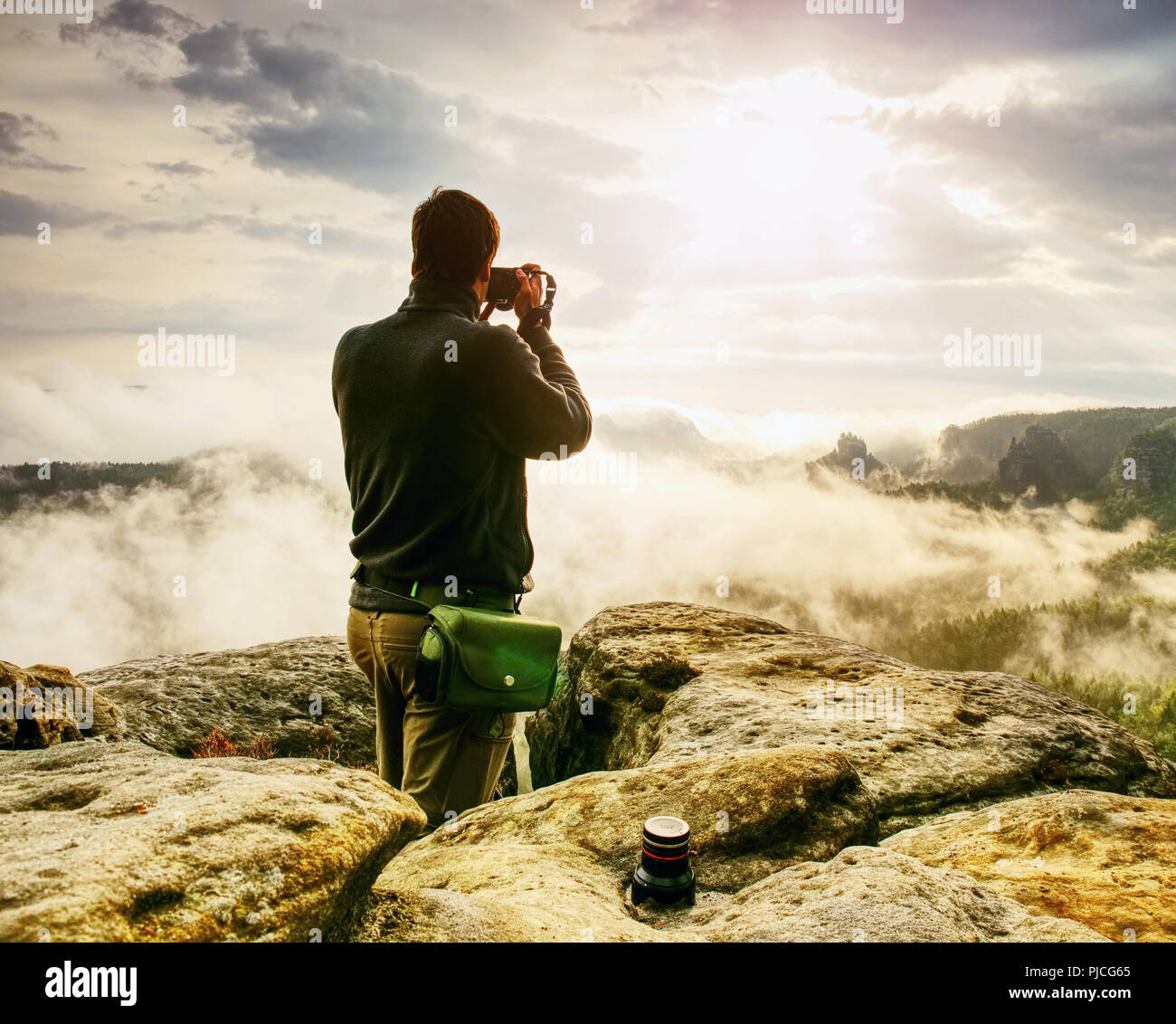 Photographer looks into fall landscape through camera viewfinder. Man ...