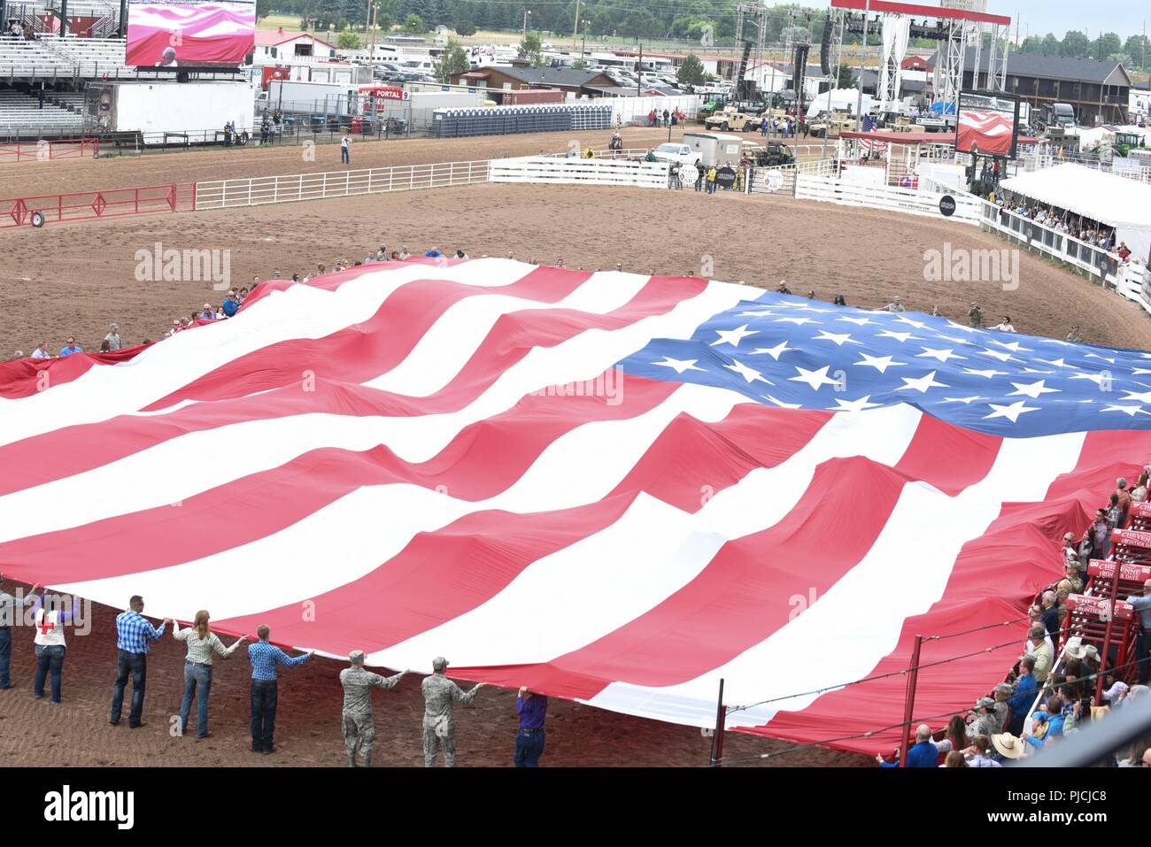 Members of the military and local community present the American flag ...