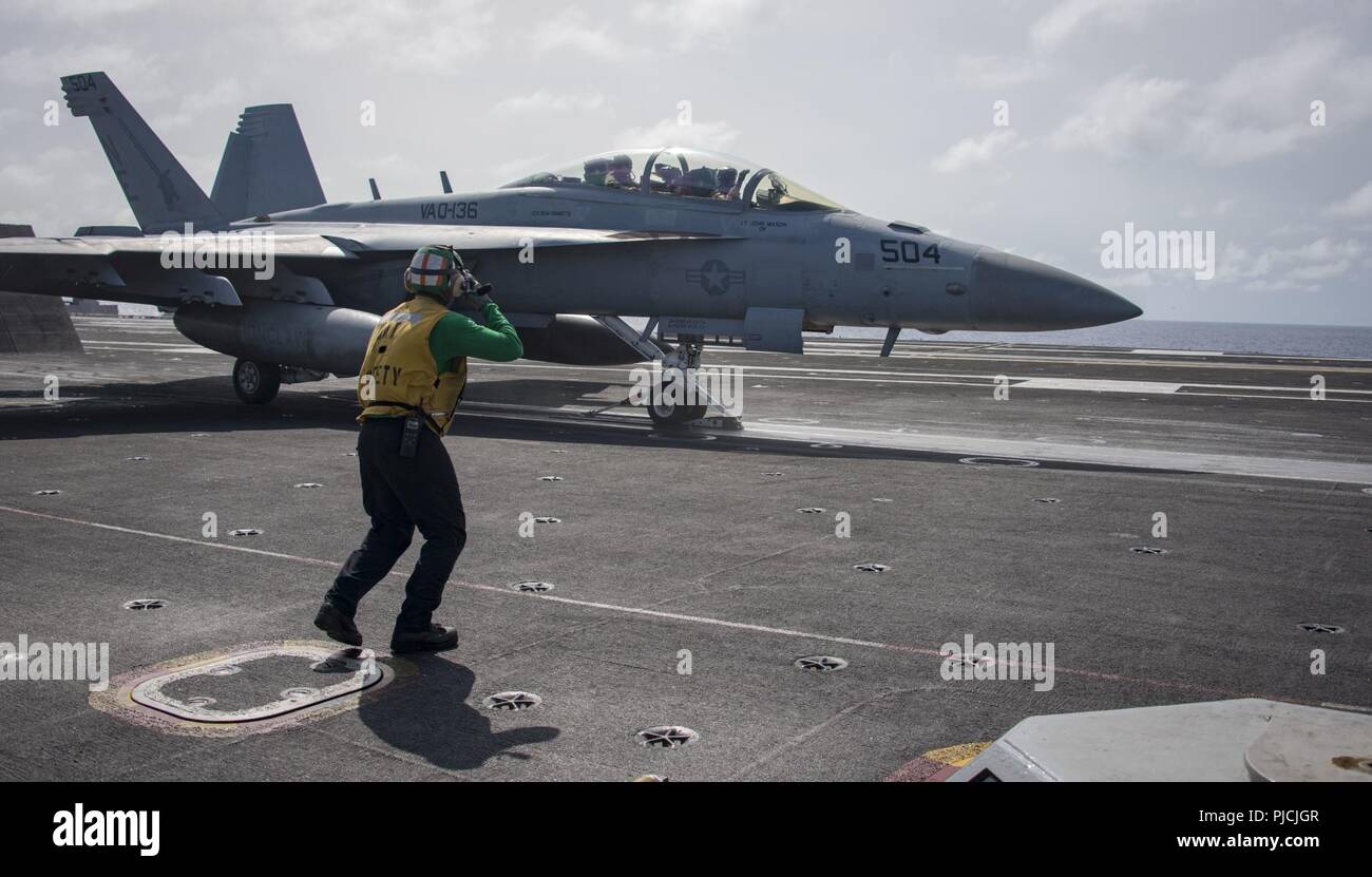 OCEAN (July 22, 2018) A Sailor salutes the crew of an EA-18G Growler ...