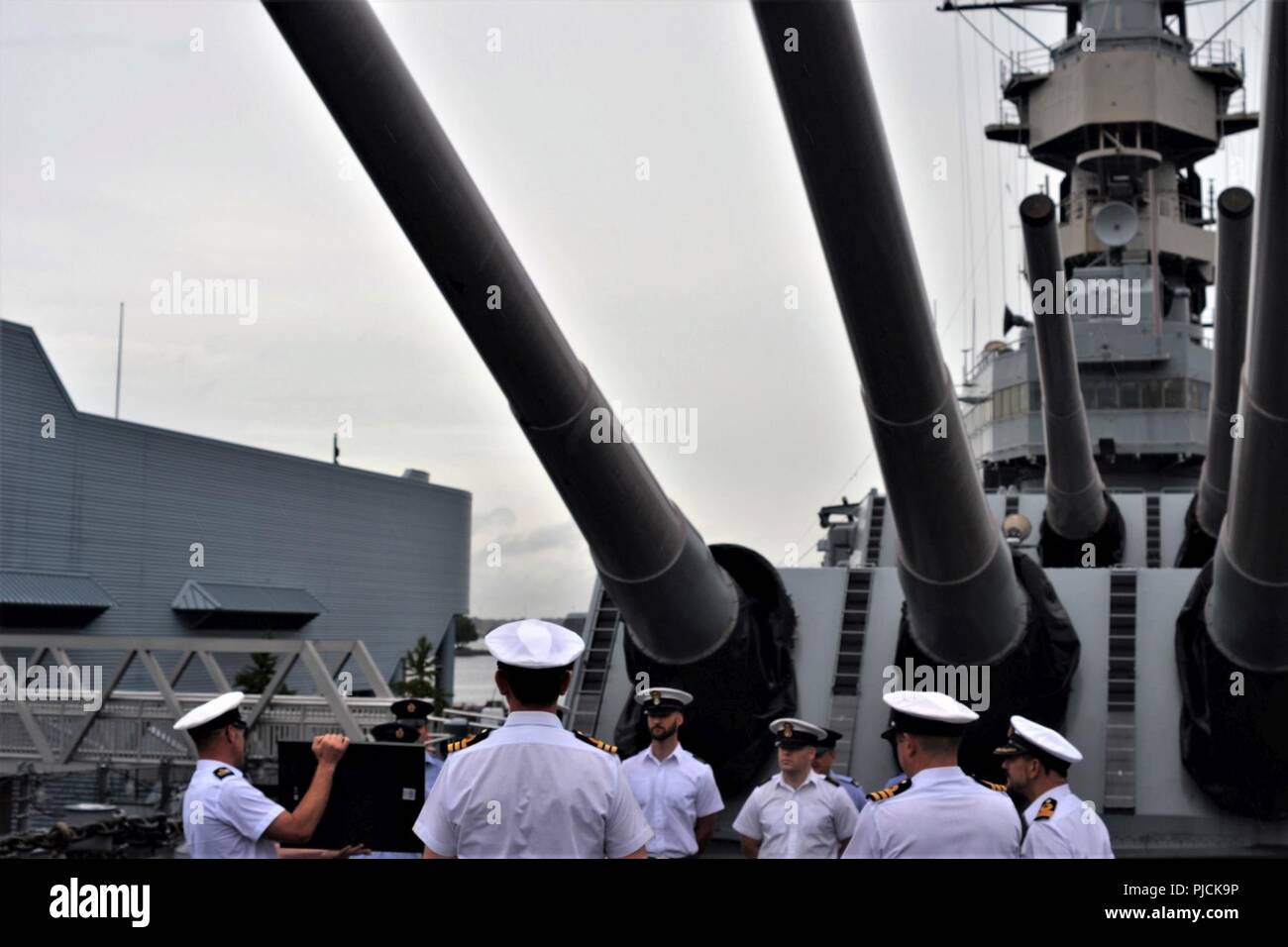 Service members with the UK Royal Navy are pictured in-front of turret ...