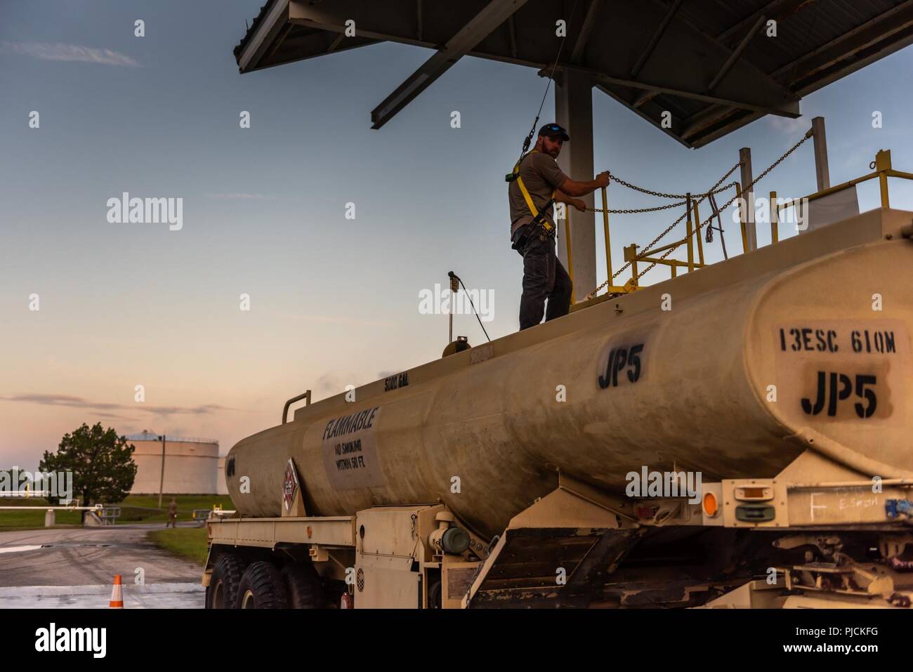 An employee from the Defense Logistics Agency gages a tanker from the ...