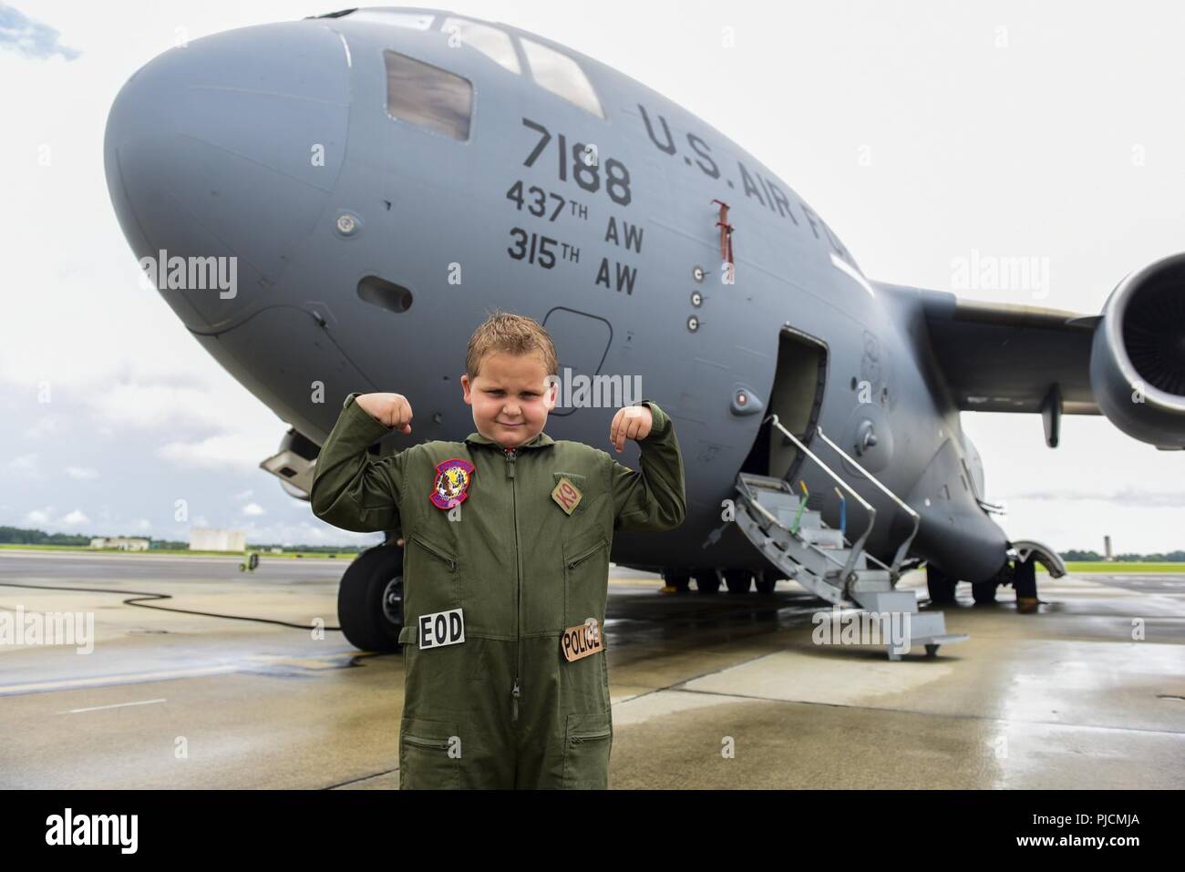 Caleb Pettit, 9, flexes his muscles in front of a C-17 Globemaster III ...