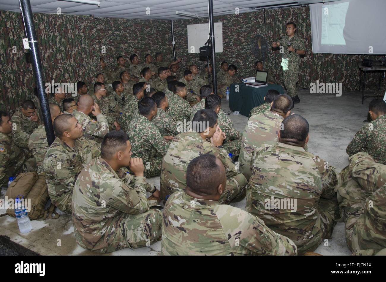 Soldiers with the 15th Royal Malay Regiment, and Charlie Company, 100th ...
