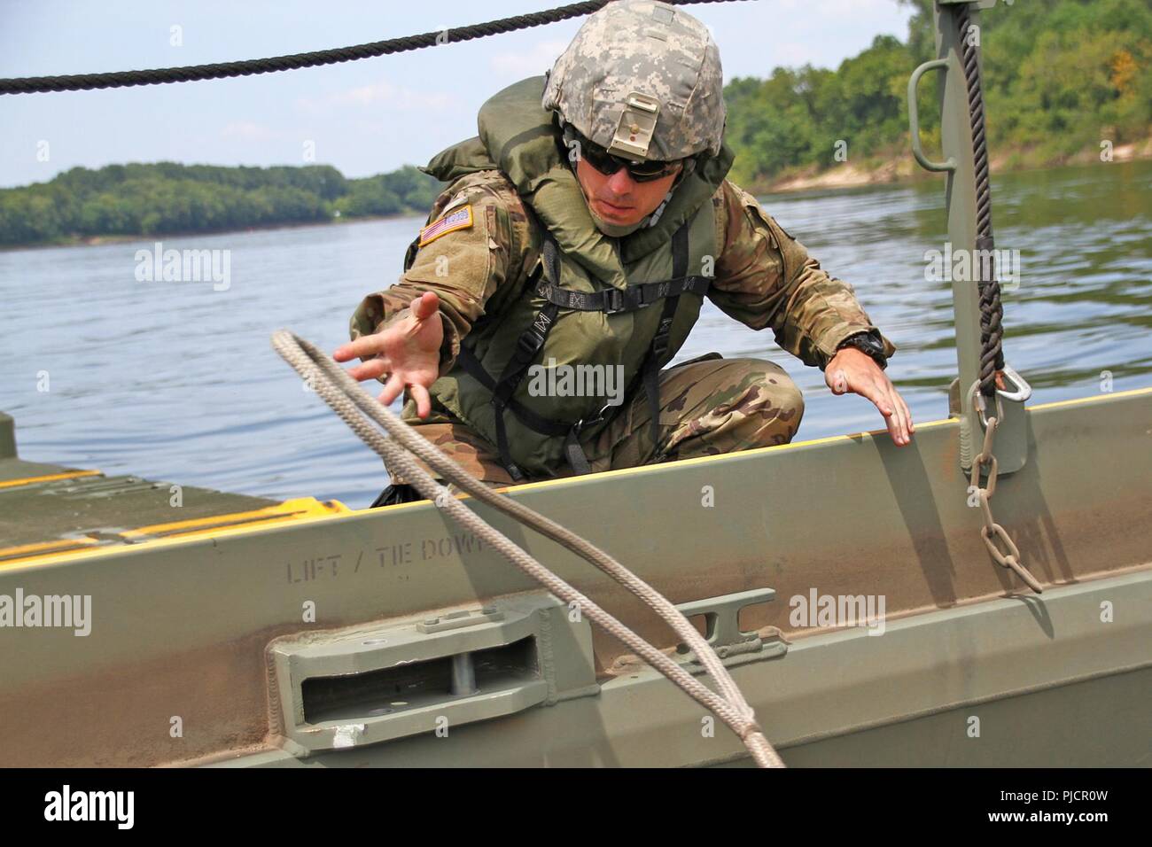 Spc. Tyler Browning with the 2061st Multi-Role Bridge Company unties a ...